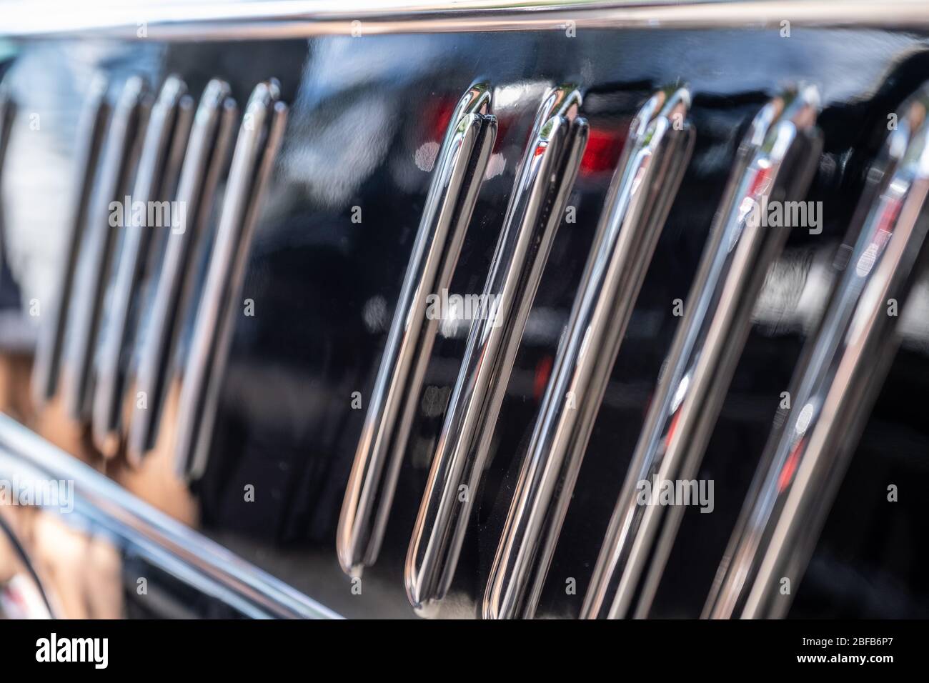 A chrome front radiator grille from an old vintage black car Stock ...