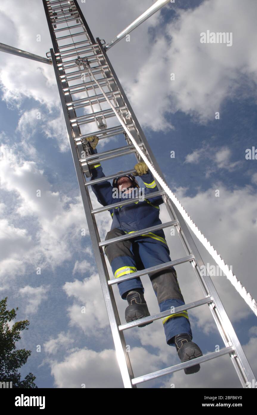 Against a blue sky a fire fighter from Hertfordshire Fire & Rescue ...