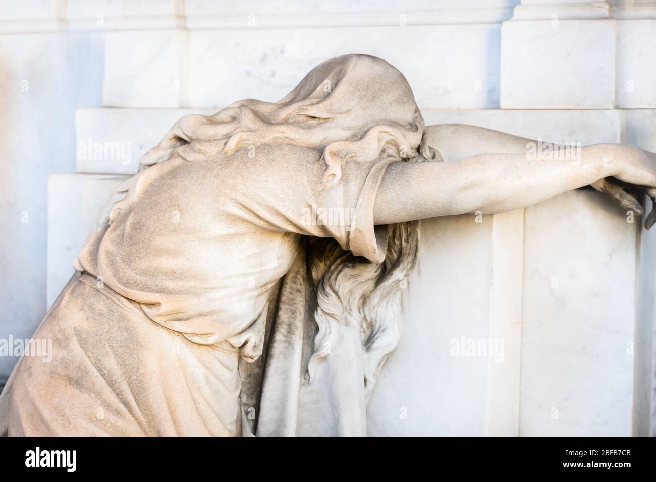 sculpture of stone granite young woman sitting at old cemetery. Closeup ...