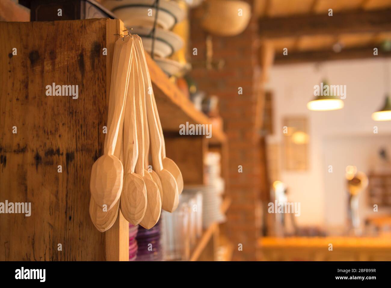 Wooden spoon hanging from a wooden shelf Stock Photo - Alamy