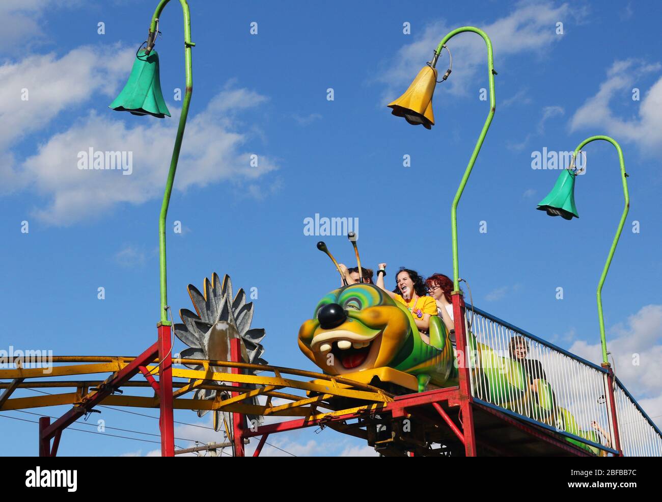 Roller Coaster Carnival Ride with teen girl riders. Cartoon Bug themed ...