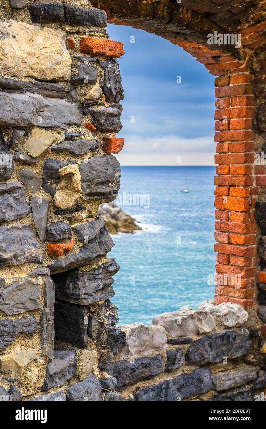View of Ligurian sea water through brick stone medieval wall window in ...