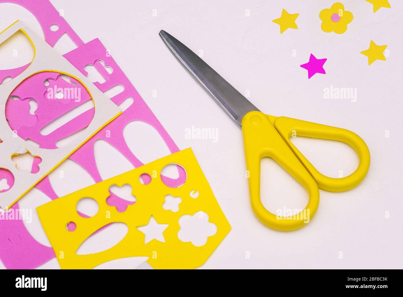 Scissors and paper with figures on a white table. Cutting out of ...