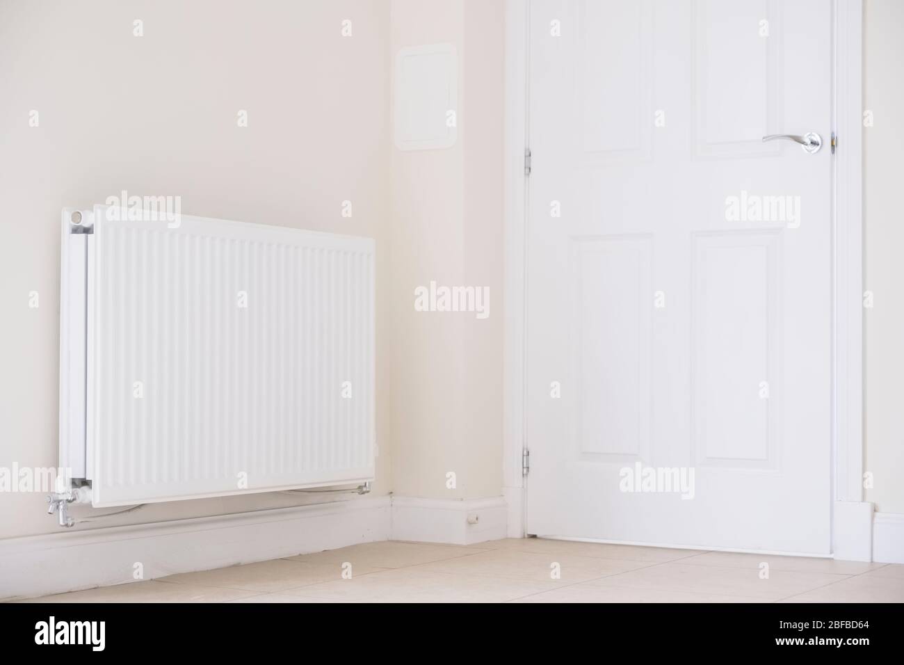 New white radiator white on pale wall house interior Stock Photo - Alamy