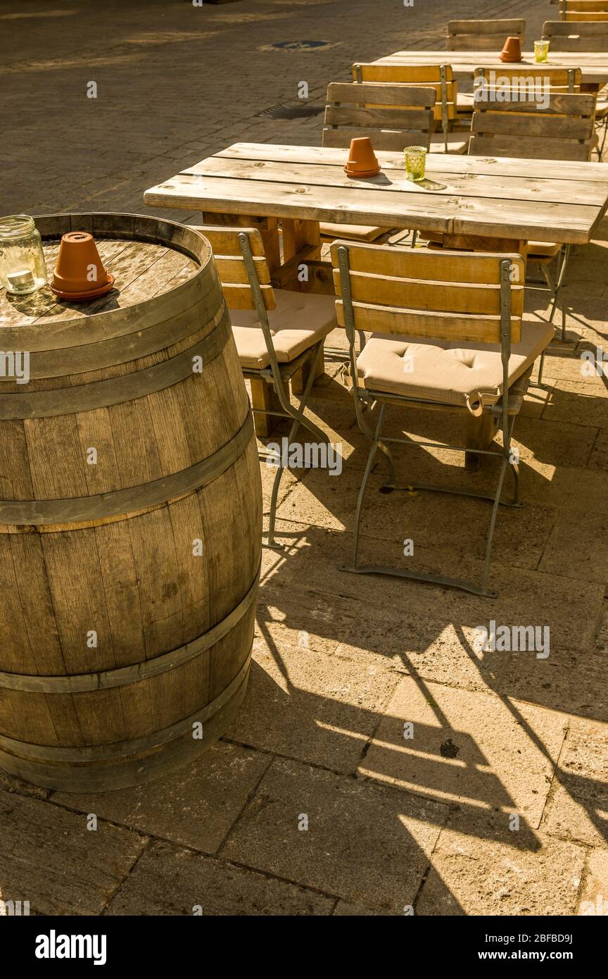 Outside seating of a wine bar with tables chairs and barrels as bar ...