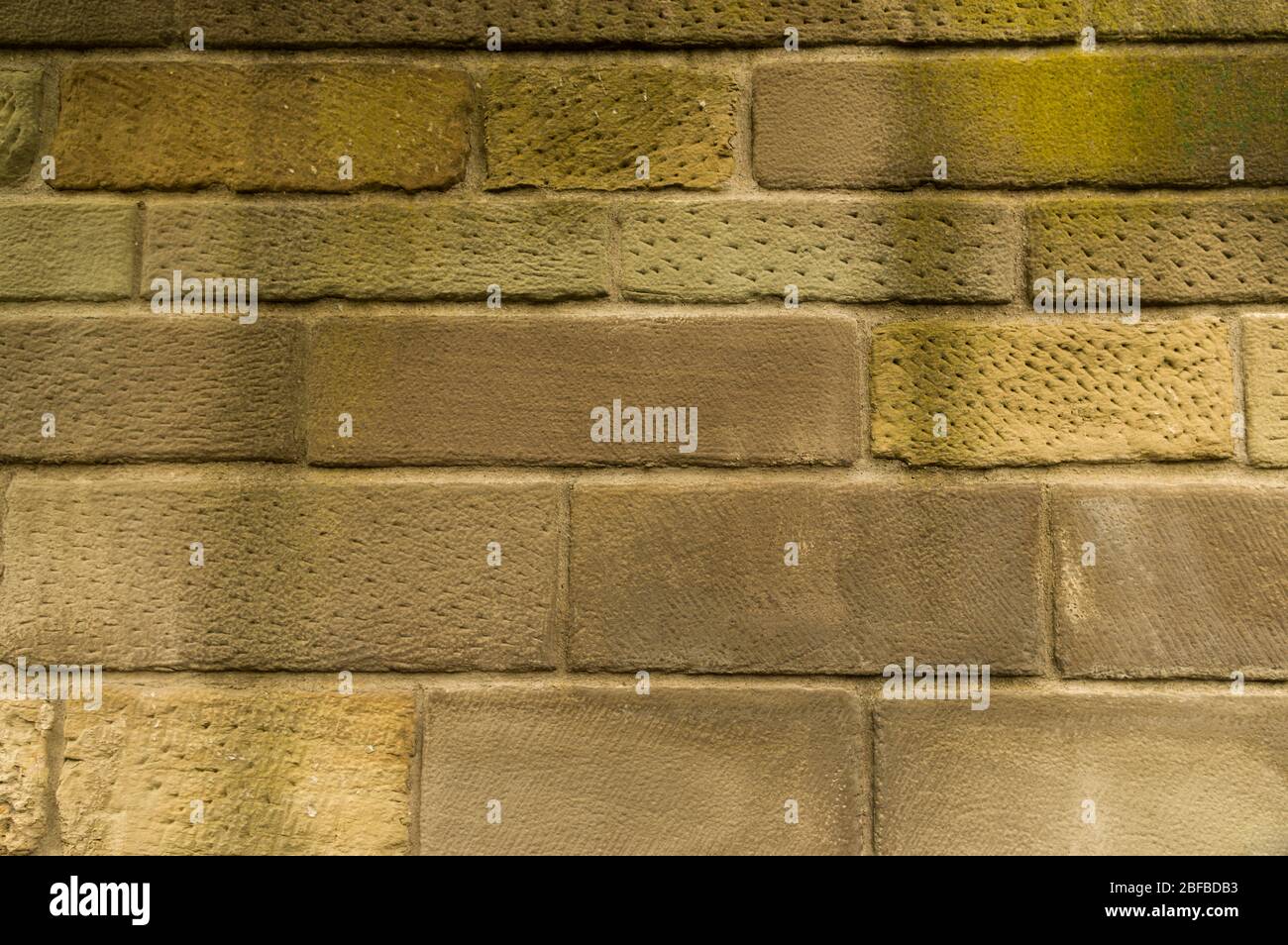 Natural stone sandstone wall with stones of different sizes brightly ...