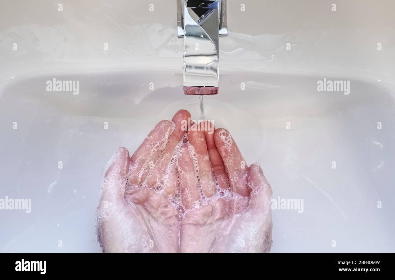 Soapy wet hands washing with blue anti-bacterial soap under tap Stock ...