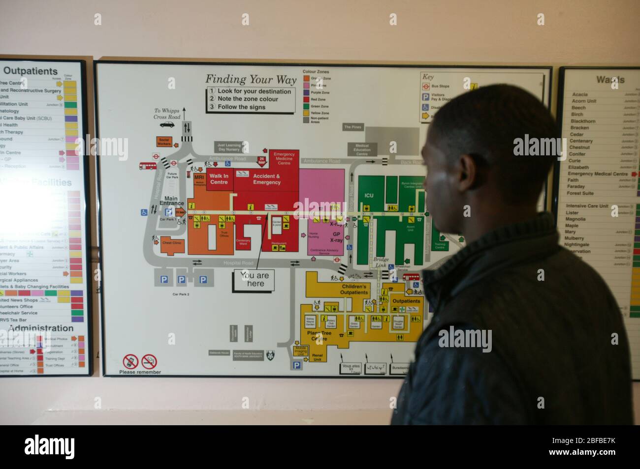 Young man reading a hospital map Stock Photo - Alamy