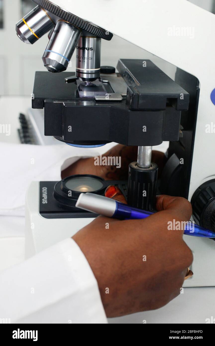 Close up of a scientist's hands operating a microscope Stock Photo - Alamy