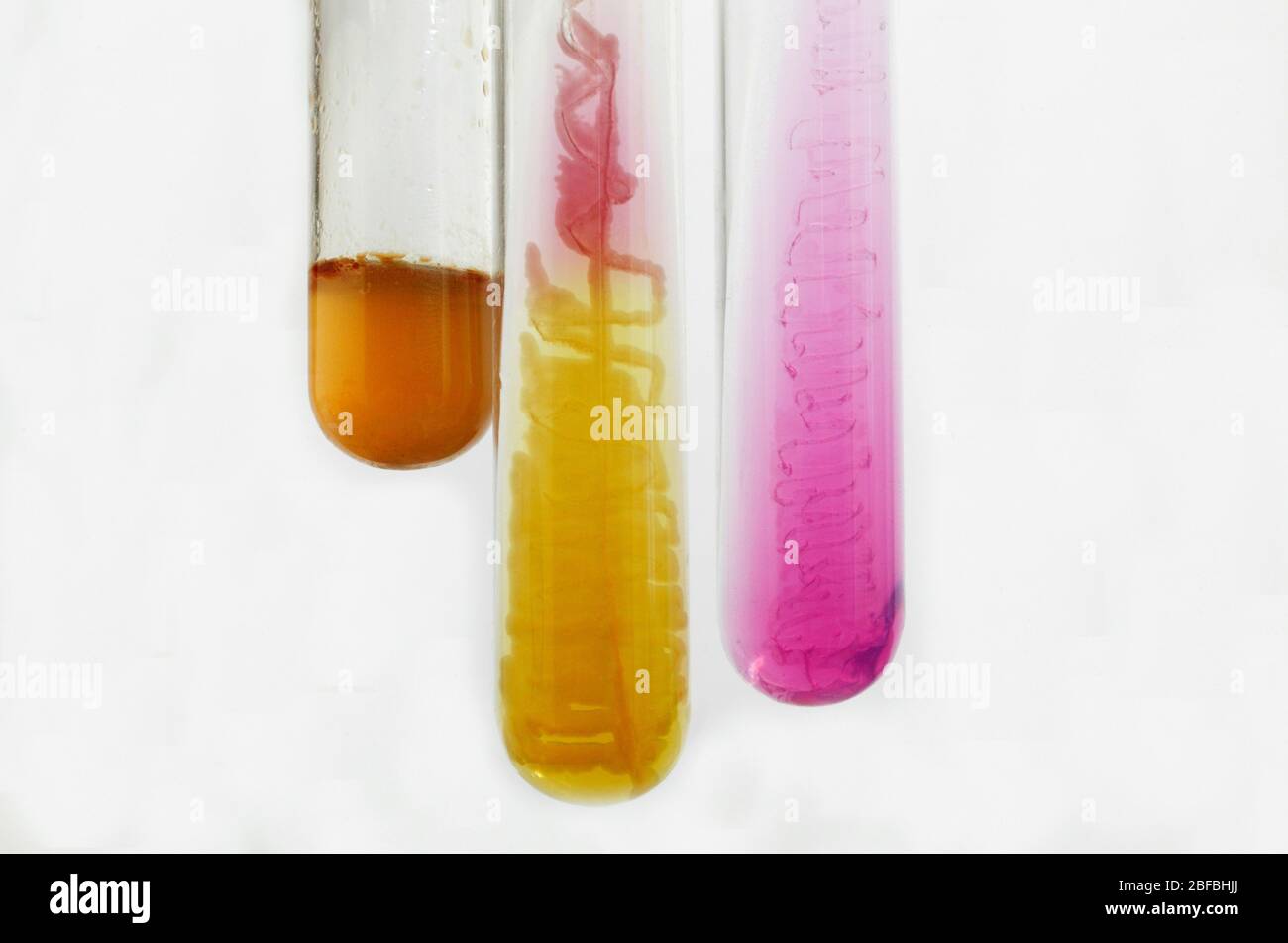 Three glass test tubes containing multi-coloured liquid Stock Photo - Alamy