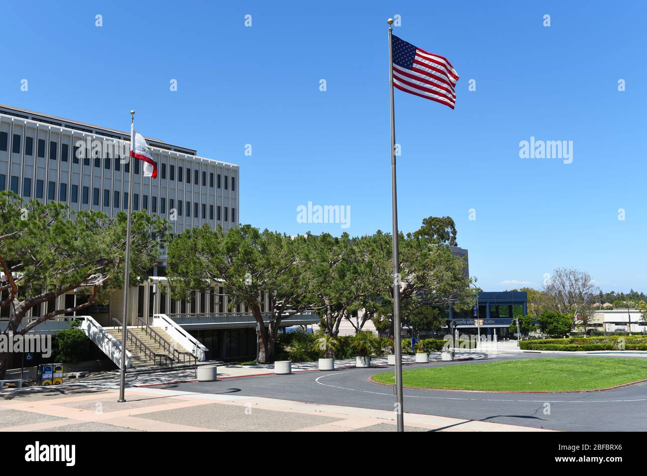 IRVINE, CALIFORNIA - 16 APRIL 2020: Flag pole with Aldrich Hall on the ...