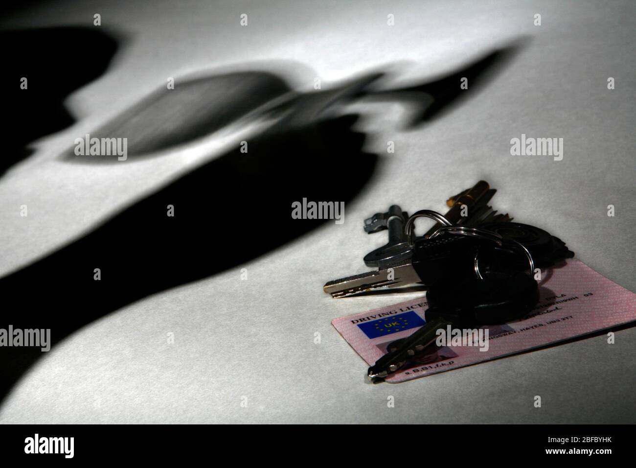 The Shadow of a man drinking alcohol with his driving licence and car ...