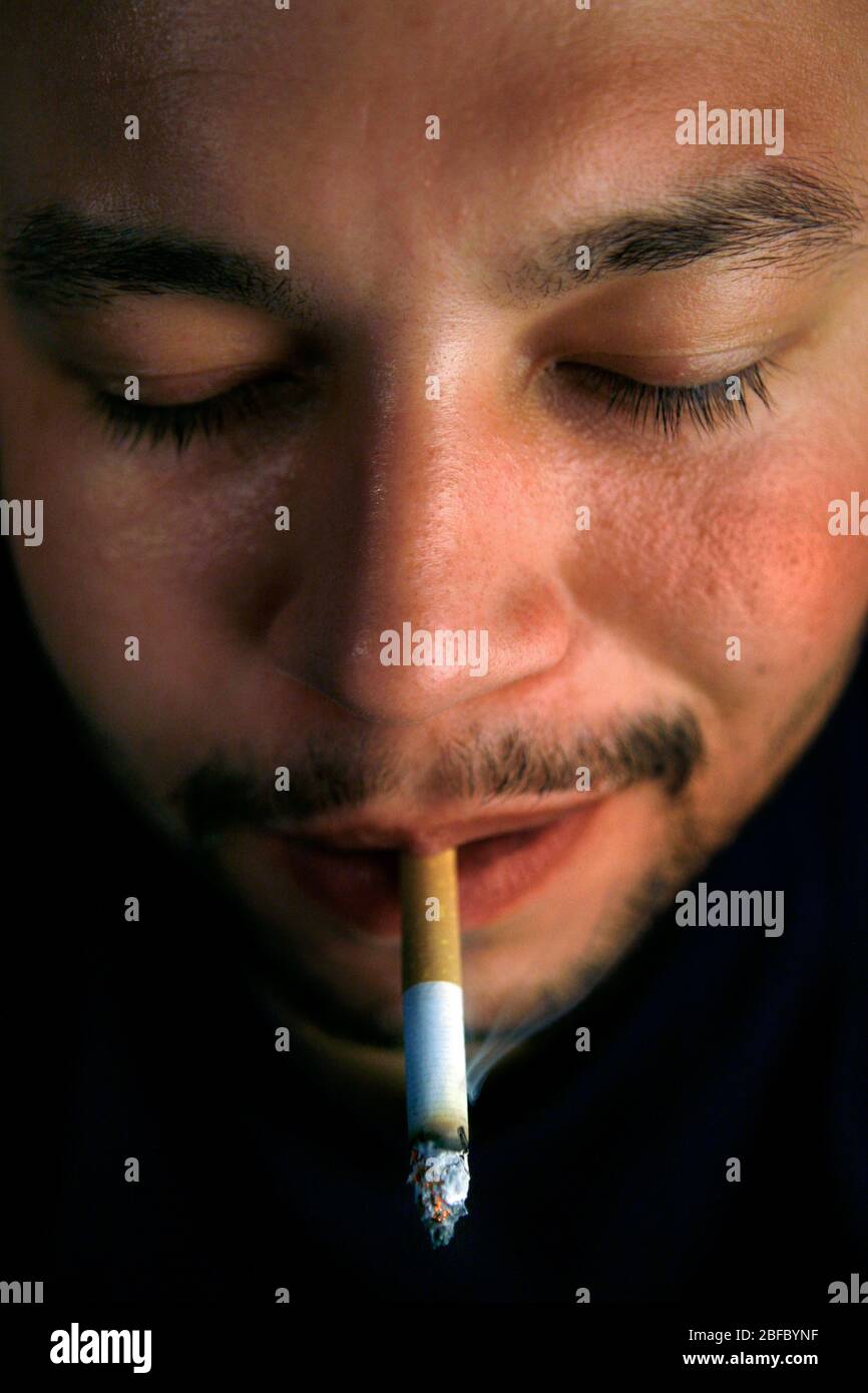 A close-up picture of a man's face smoking a cigarette Stock Photo - Alamy