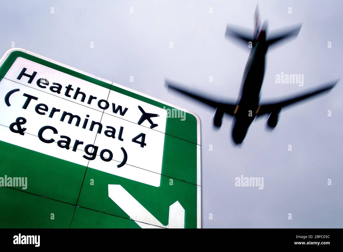 An aeroplane flying above road signs near Heathrow International ...