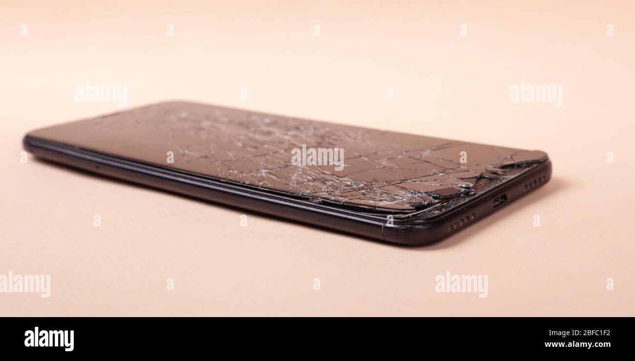 broken phone on a beige background close-up broken glass display ...