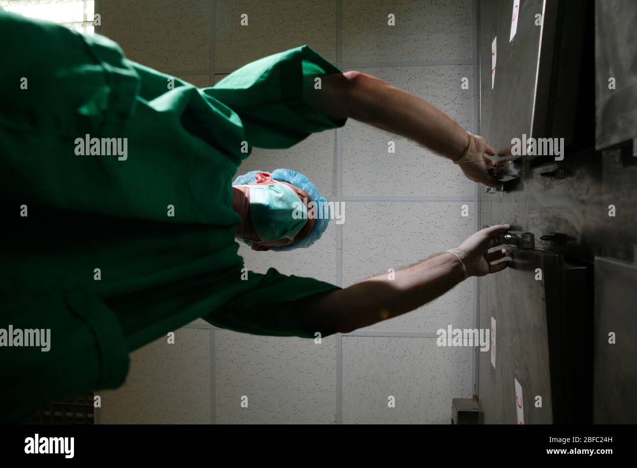 A mortuary technician opens the doors to a cold storage facility Stock ...