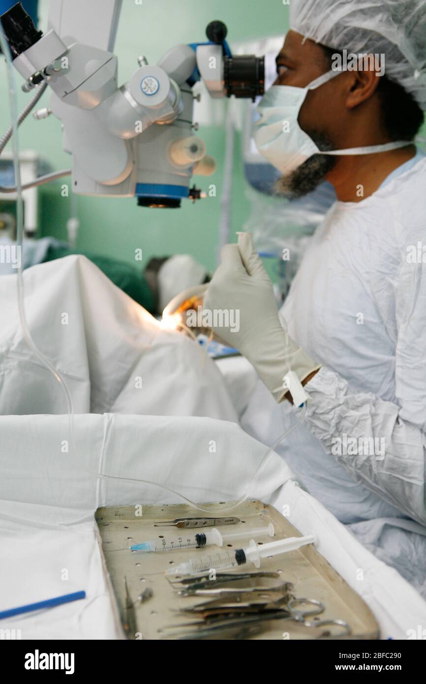 A surgeon uses a microscope during cataract surgery. The microscope ...