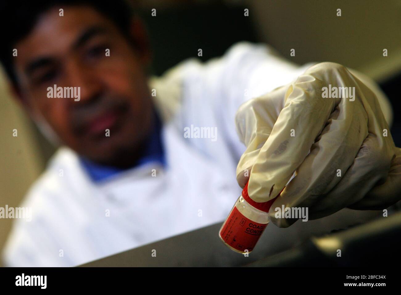 A pathologist examines a small glass bottled specimen Stock Photo - Alamy