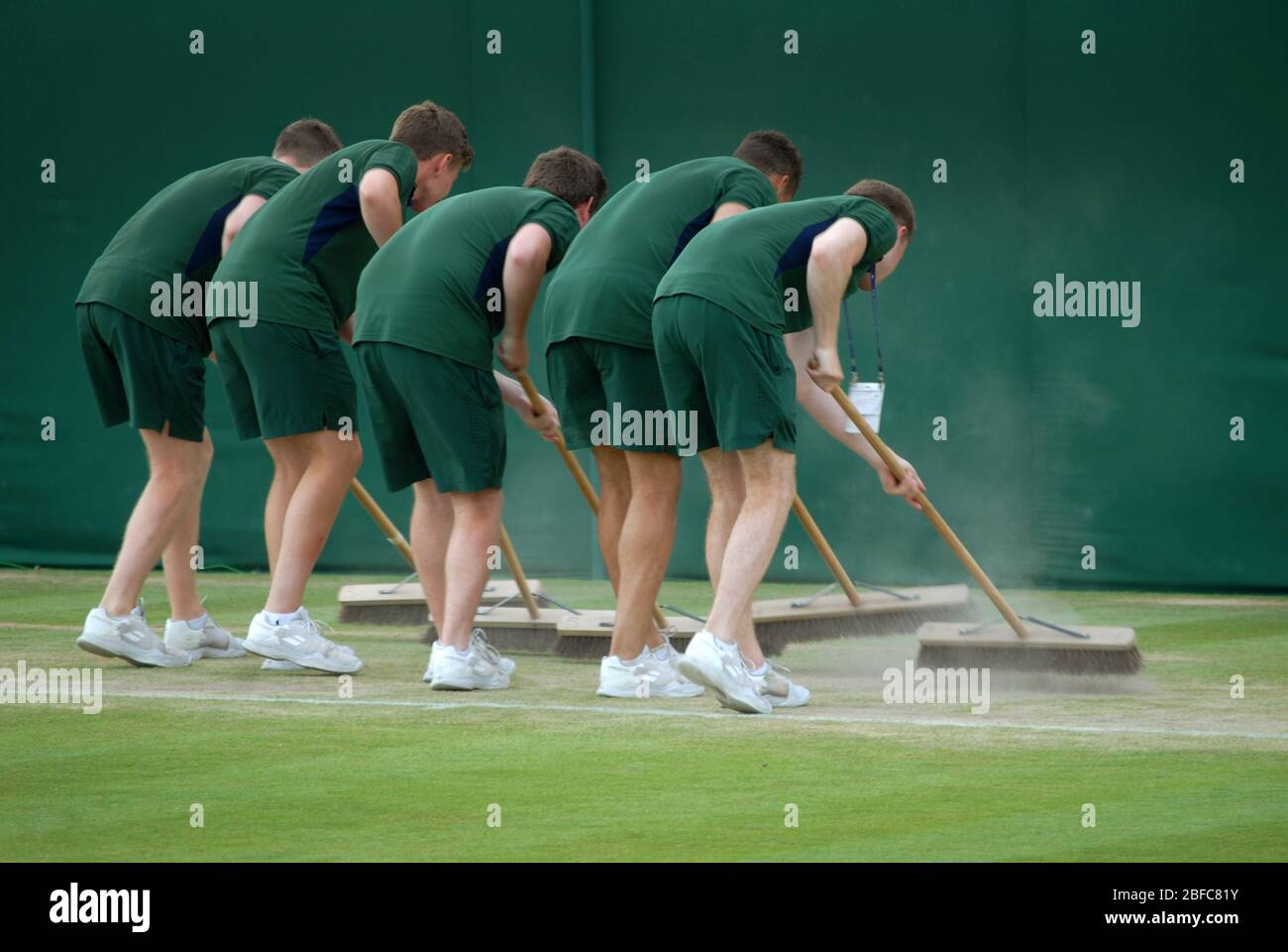 Ground staff sweep the courts of the Wimbledon Championships at the All ...
