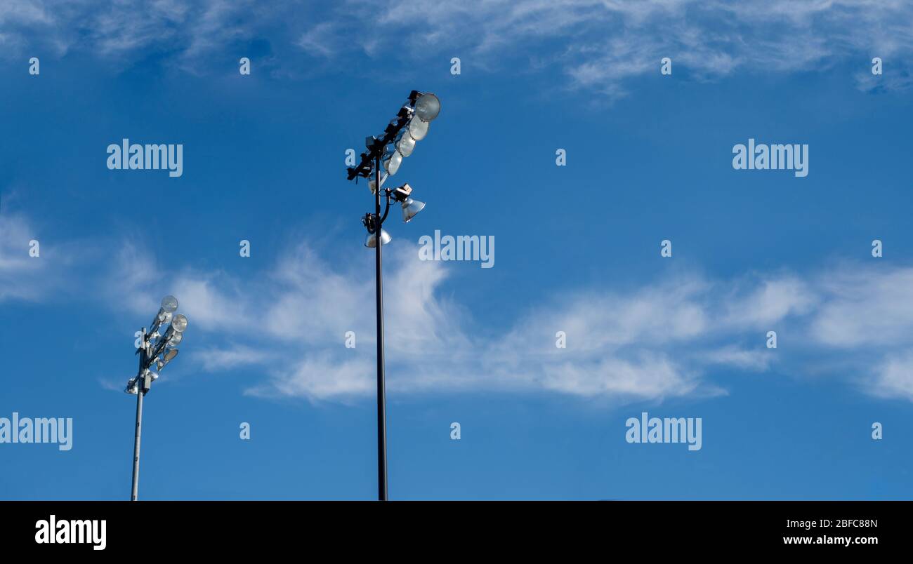tall pole high powered event lights during blue day sky with white ...