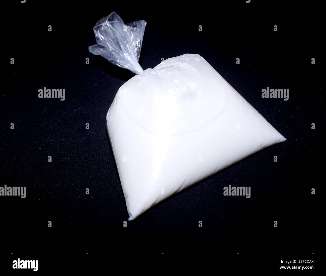 milk in a plastic polythene packet, dangerous for health on black ...