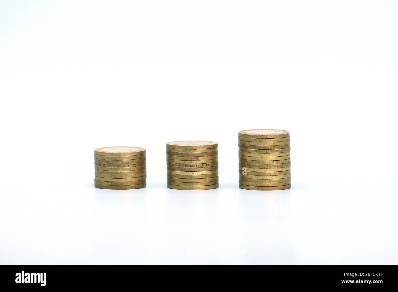 Piles of golden metallic coins. Columns of coins of different heights ...