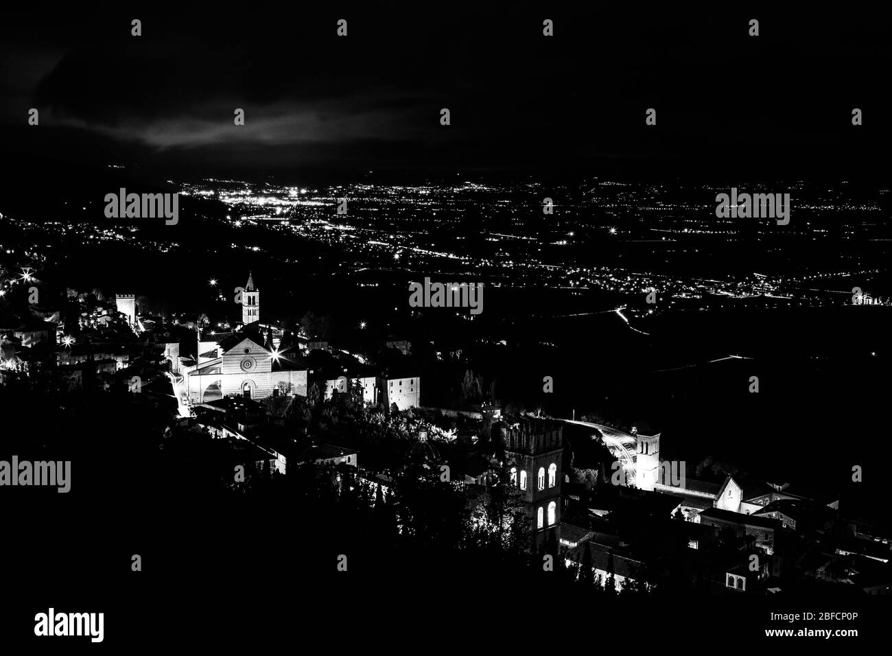 Aerial view of Assisi town (Umbria, Italy) and valley at night, with ...