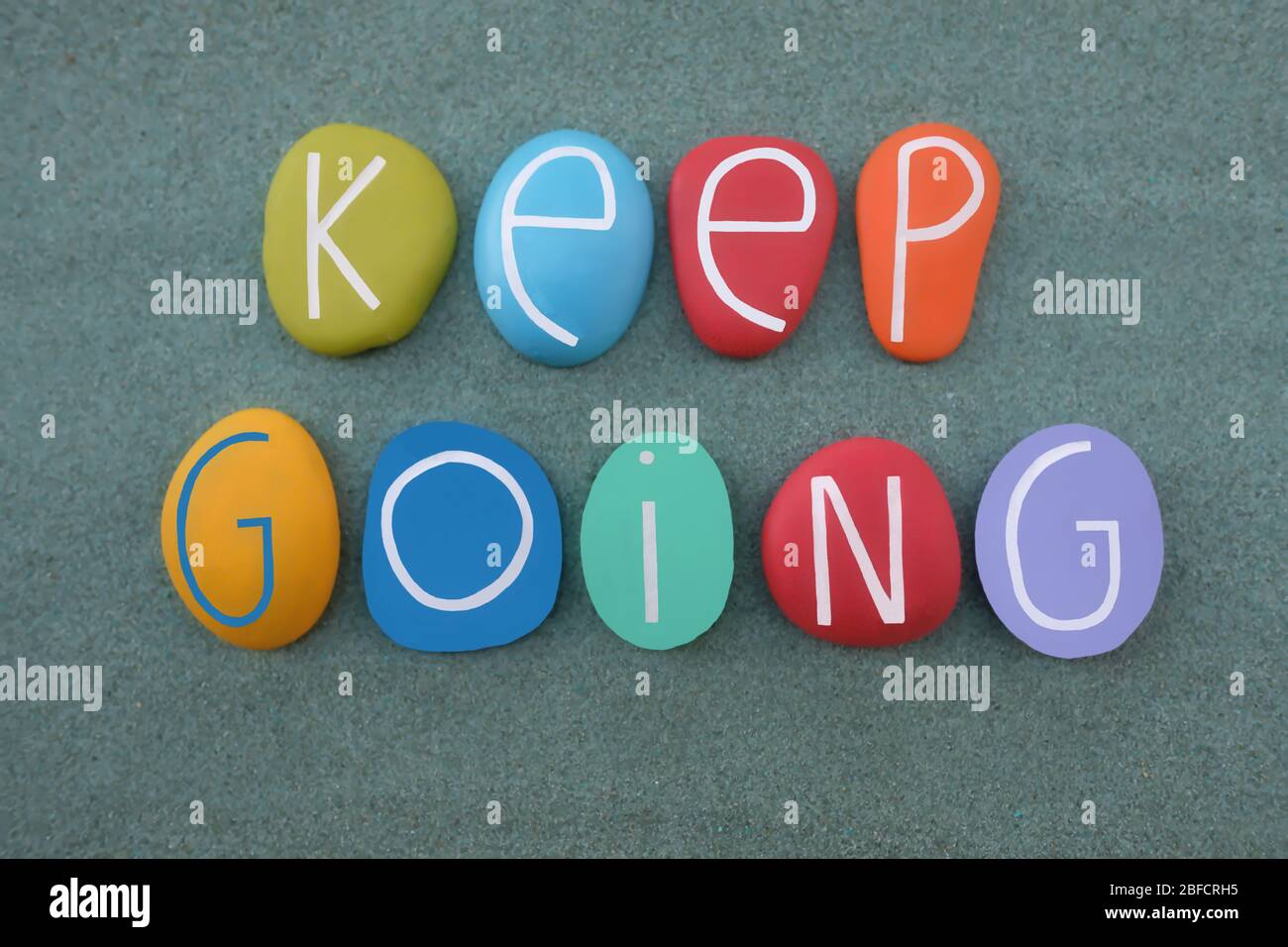 Keep Going text composed with handmade multi colored stone letters over ...