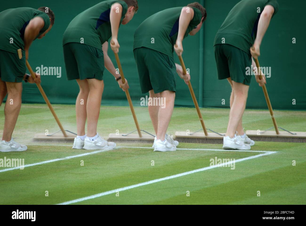 Ground staff sweep the courts of the Wimbledon Championships at the All ...