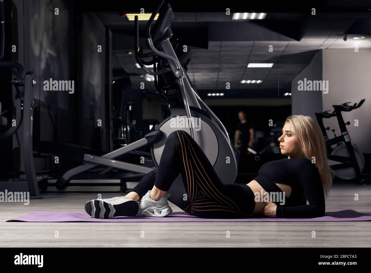 Pretty girl laying on fitness mat in gym Stock Photo - Alamy