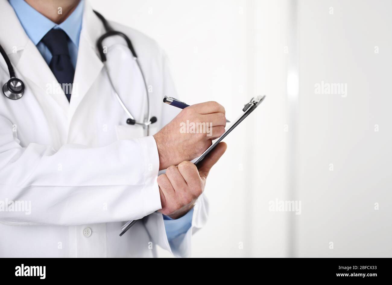 close up doctor hand writing prescription on folder isolated on white ...