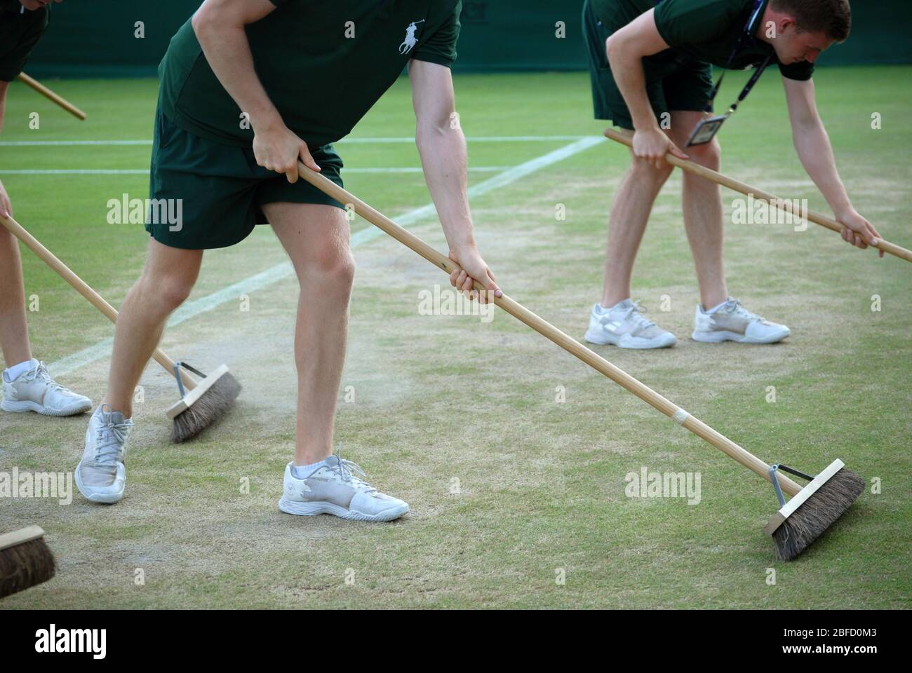 Ground staff sweep the courts of the Wimbledon Championships at the All ...