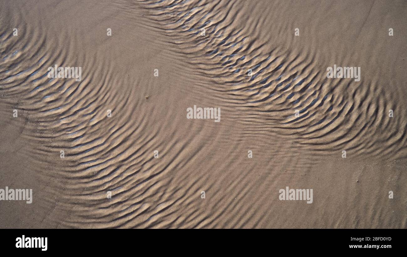 A close view of ripples on water surface created by strong wind in sand ...