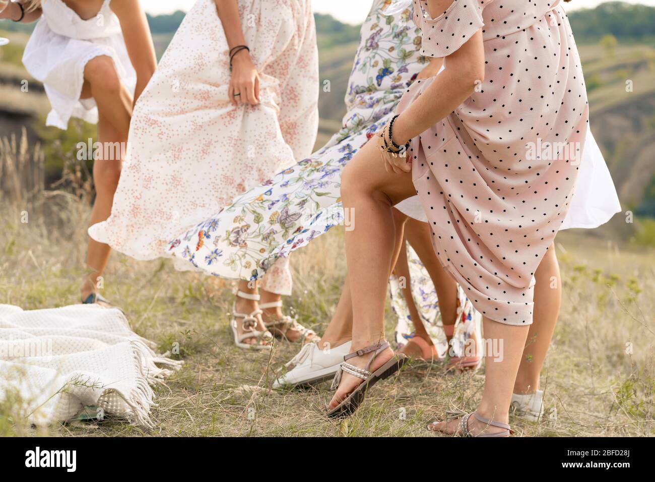 The company of female friends having fun, dancing on summerfield in ...