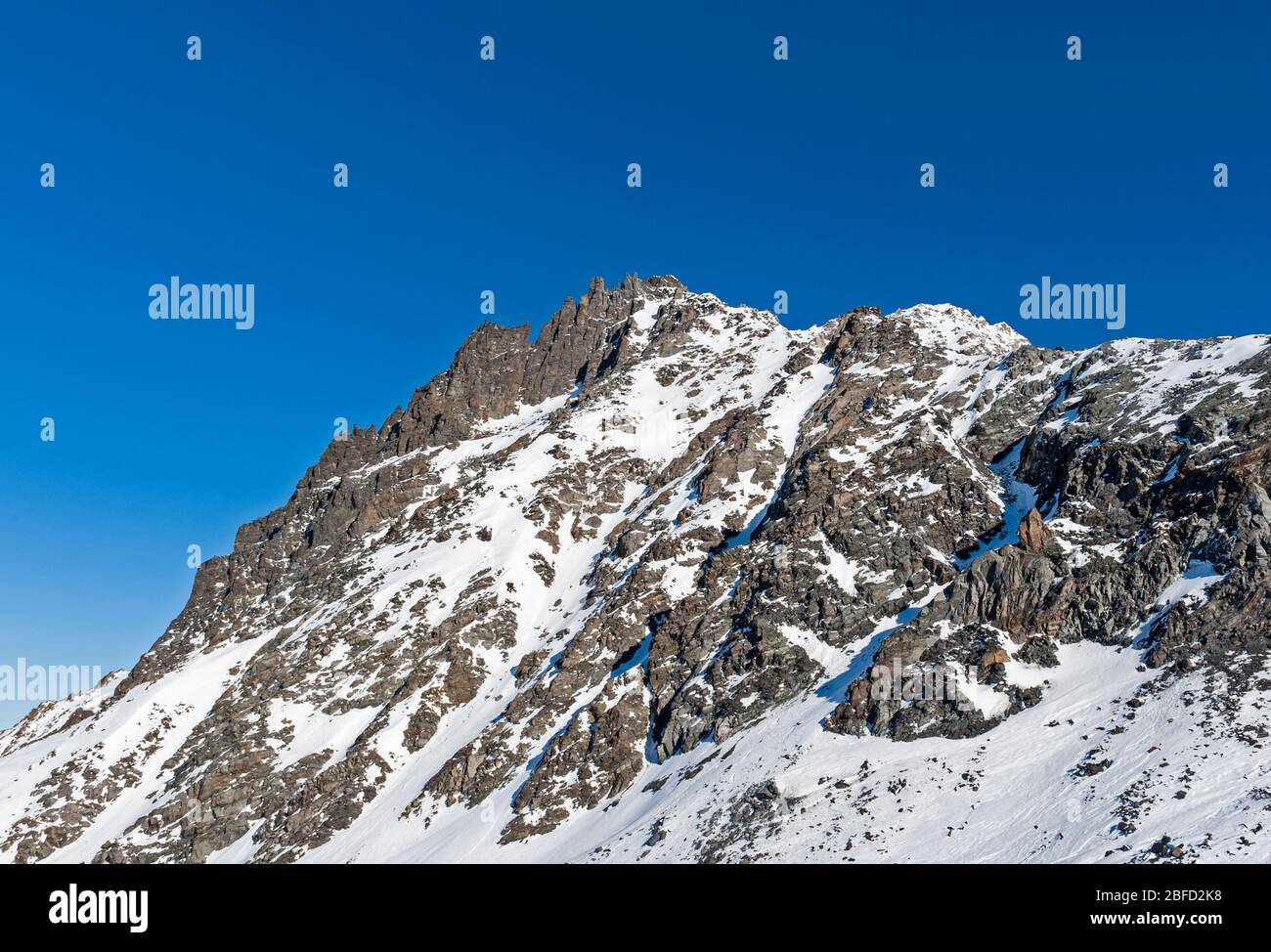 Rugged alpine rocky mountainside landscape covered in snow and ice ...