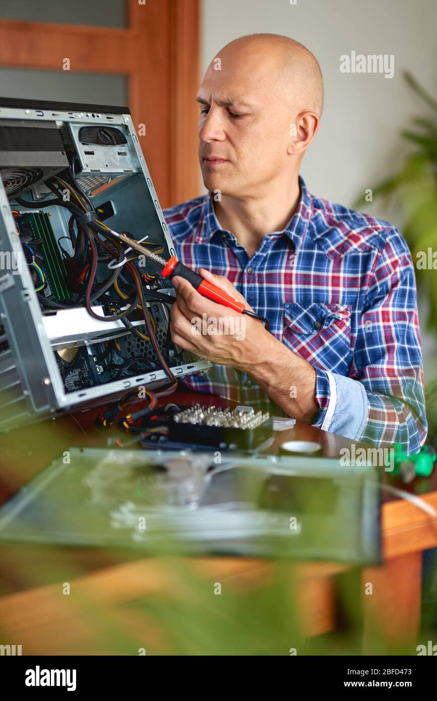 Computer engineer working on broken console at home Stock Photo - Alamy