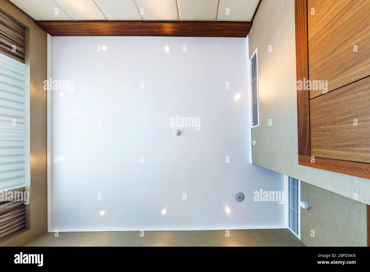 look up on suspended ceiling with halogen spots lamps and drywall ...