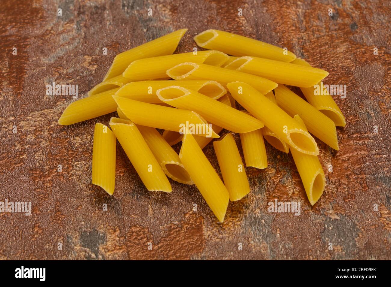 Raw penne pasta ready for bowl Stock Photo - Alamy