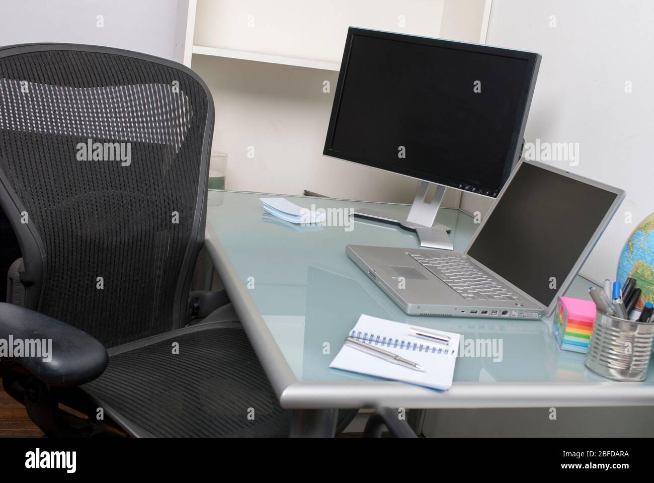 Empty view of deserted office cubicle featuring a desk chair, laptop ...