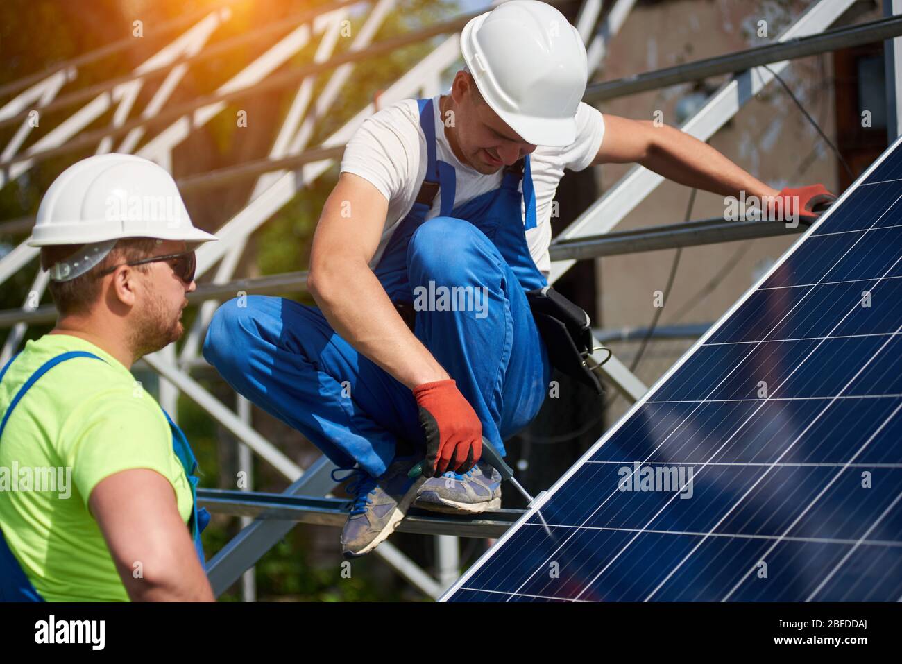 Two professional technicians installing solar photo voltaic panel to ...