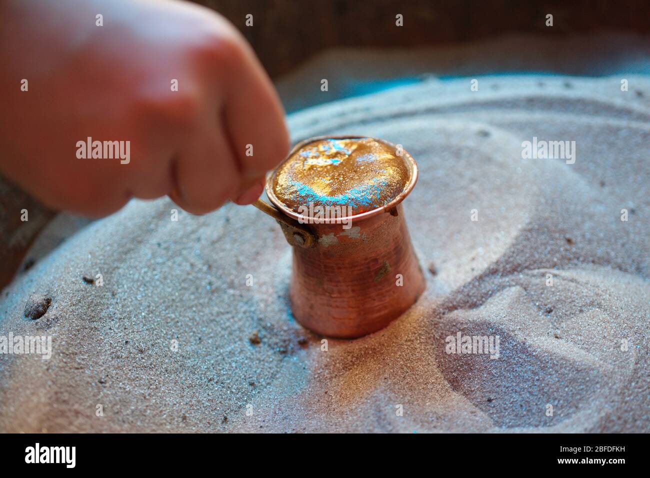 Turkish coffee culture coffee in the sand. The woman is cooking coffee ...