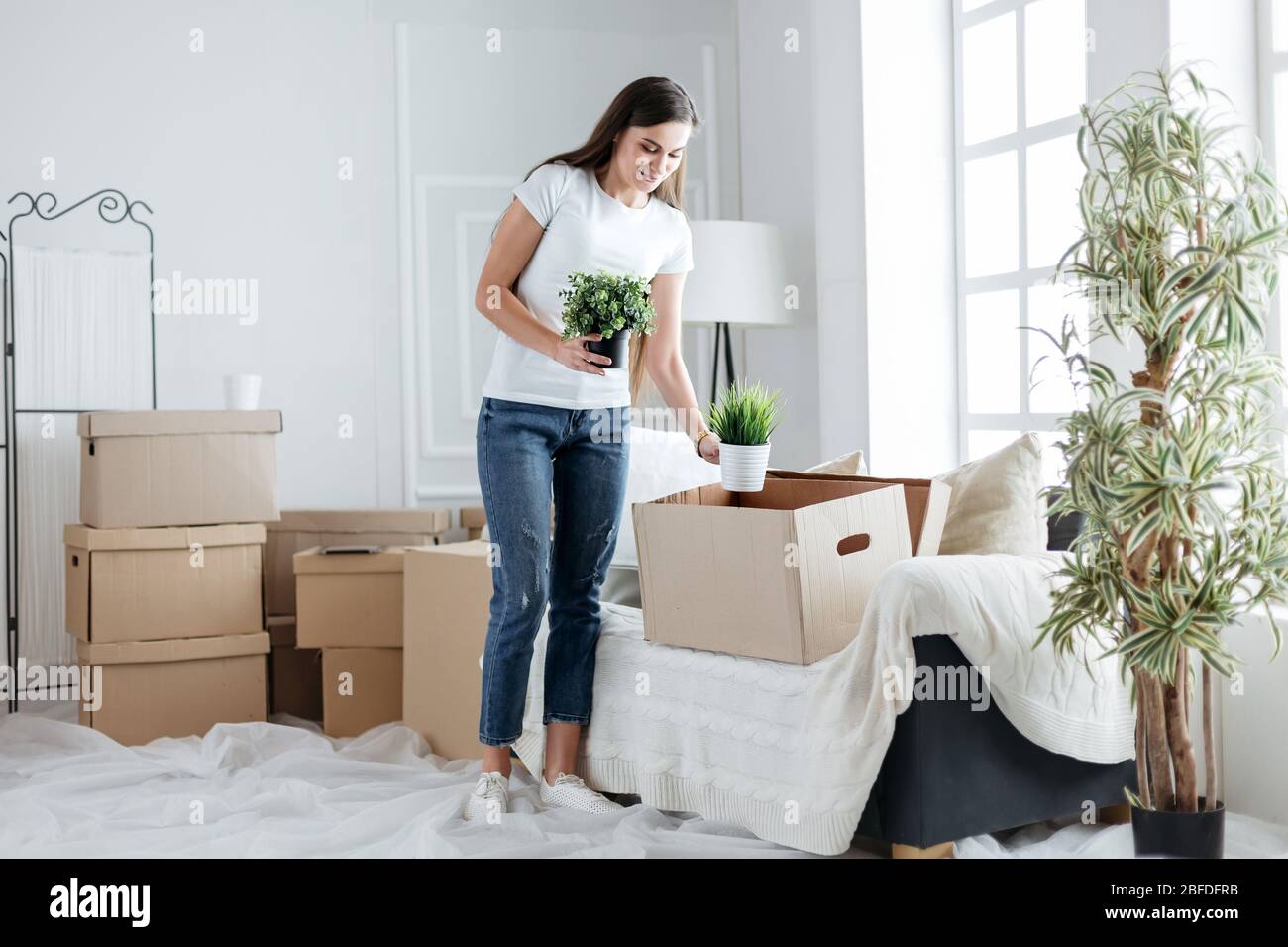 young woman taking personal items out of a cardboard box Stock Photo ...