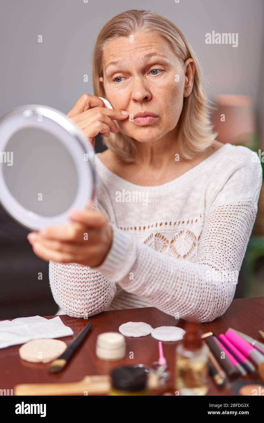 Elderly Woman Putting On Make-Up.Face aging Stock Photo - Alamy