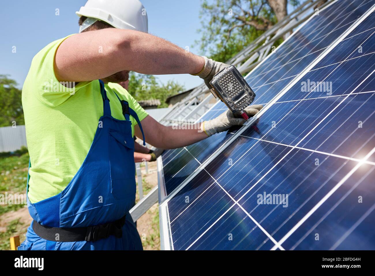 Professional technician working with screwdriver attaching solar photo ...