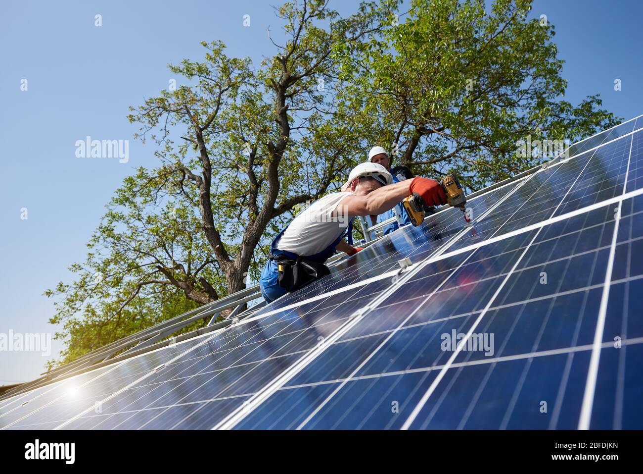 Professional technicians installing solar photo voltaic panel to metal ...