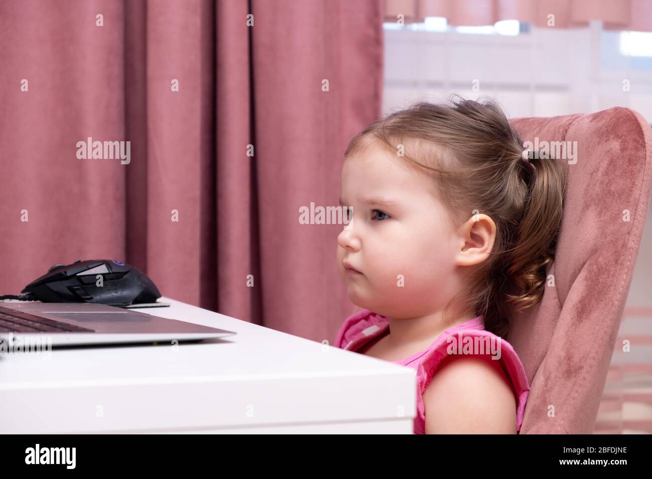 beautiful cute little girl behind laptop computer. The concept of ...