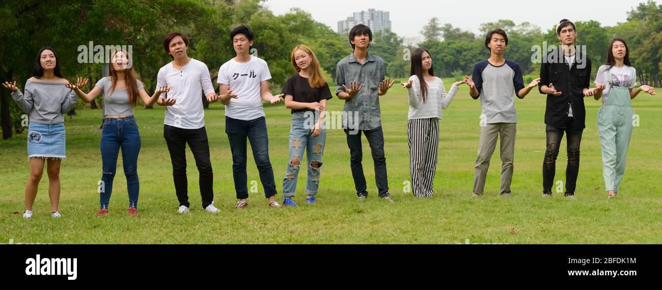 Stressed young group of friends looking frustrated together at the park ...