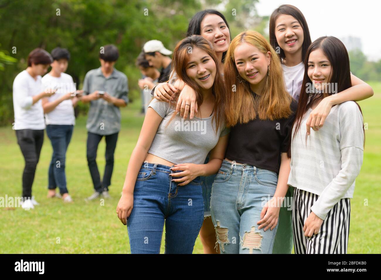 Happy young group of friends hanging out together at the park Stock ...