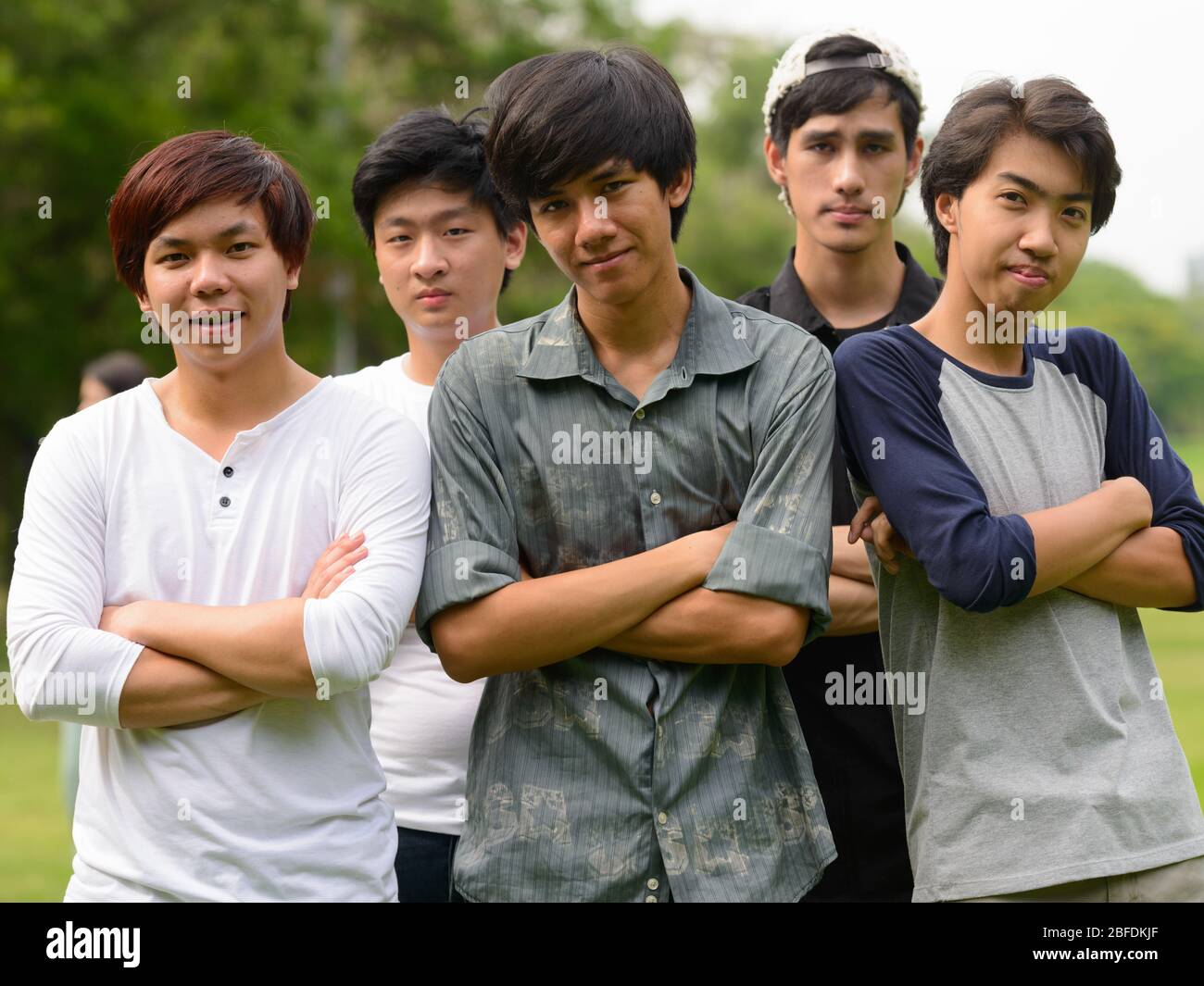 Happy young group of men as friends with arms crossed together Stock ...