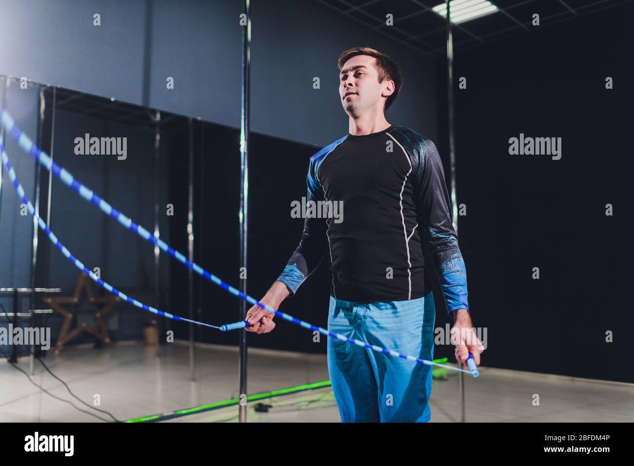 Muscular man skipping rope. Portrait of muscular young man exercising ...